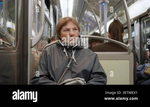 Senior woman passenger sits inside Paris metro train public transport ...
