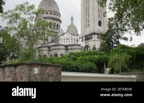 Sacre Coeur basilica church bell tower and dome stand behind green ...