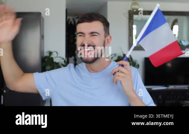 A man is waving a French flag and cheering, showing support for his ...