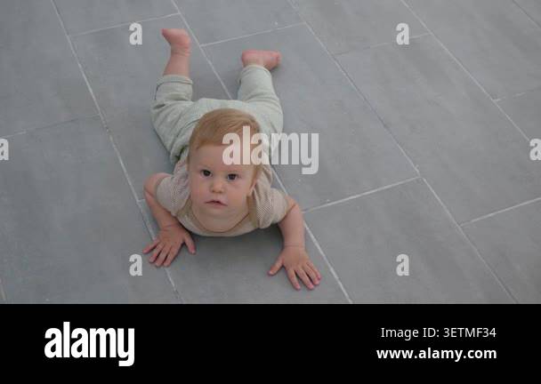 Baby learns happiness. Young child shifts from tummy lying to confident ...