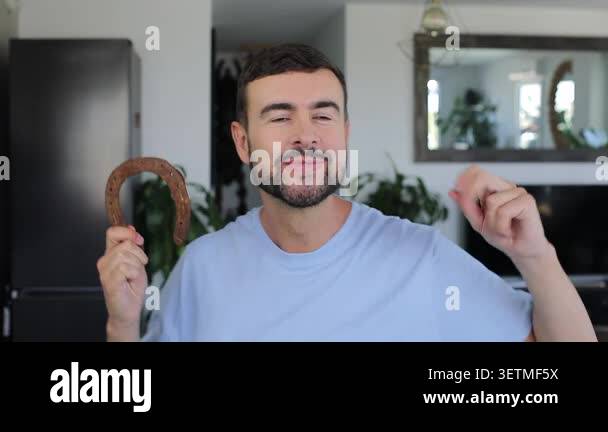 A man holding a horseshoe and making various facial expressions and ...