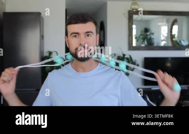 A man is using a massage roller tool to massage his neck and shoulders ...