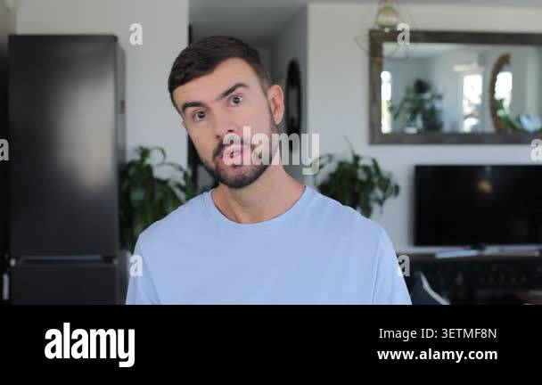 Man making a stop gesture with his hand, looking surprised and then ...