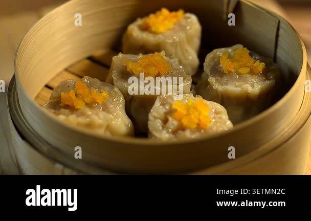 Steamed dim sum in bamboo steamer basket with on rustic wooden table ...