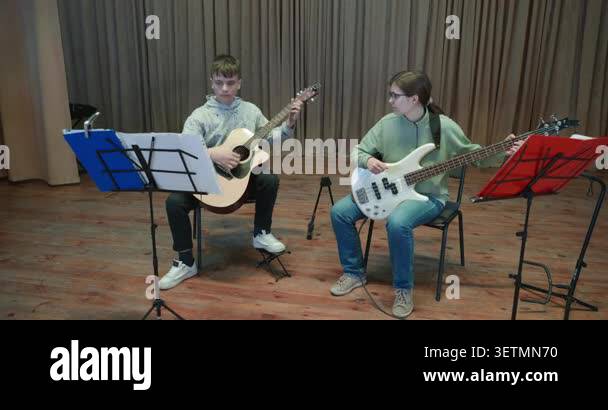 Boy and Girl Practice Playing Music on Stage. Kids Play Guitar and Bass ...