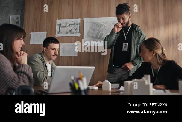 In an office, a presenter shares project ideas as three team members ...