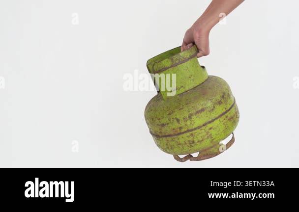 A person's hand is holding a 3 kg LPG gas cylinder. LPG gas is used as ...