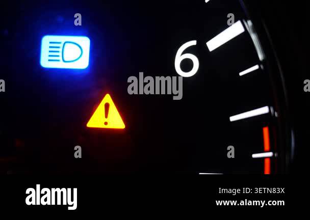 Car dashboard master warning light and high beam indicator close up ...