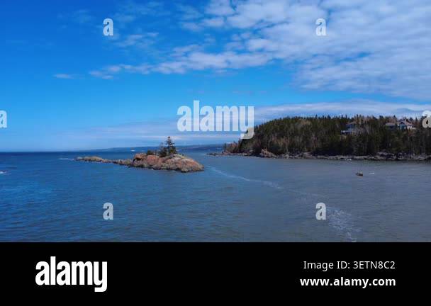Drone footage of le-aux-Trois-Sapins, a rocky islet with resilient fir ...