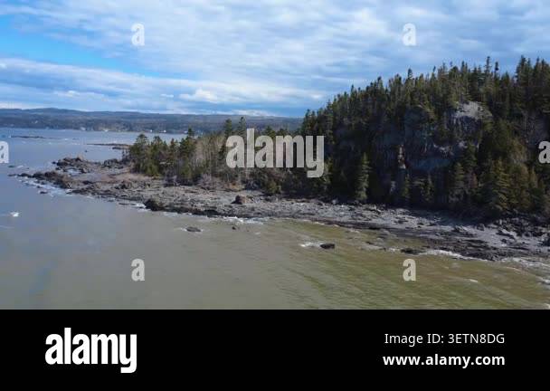Drone flight capturing dramatic coastal scenery where waves meet rocky ...