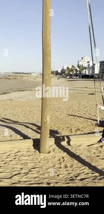 A child is swinging on a swing at the beach Stock Video Footage - Alamy