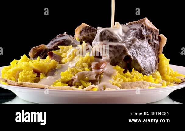 Cinematic close up of pouring traditional jameed yogurt sauce over ...