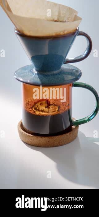 Close-up of pour-over coffee brewing on a white table in bright high ...