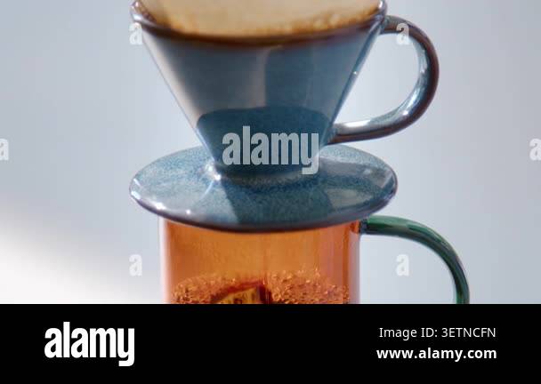Close-up of pour-over coffee brewing on a white table in bright high ...