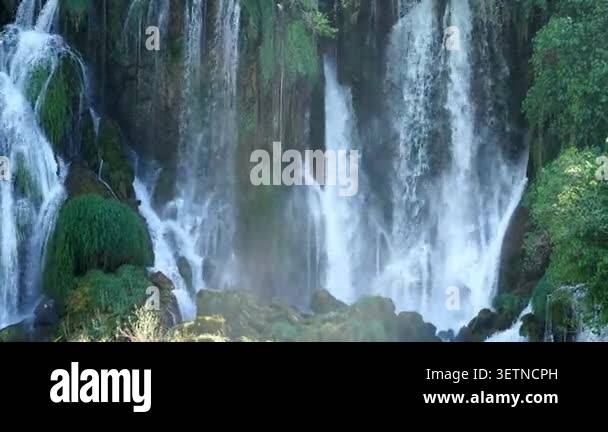 Horizontal close-up video of water flowing down over rocks in a natural ...