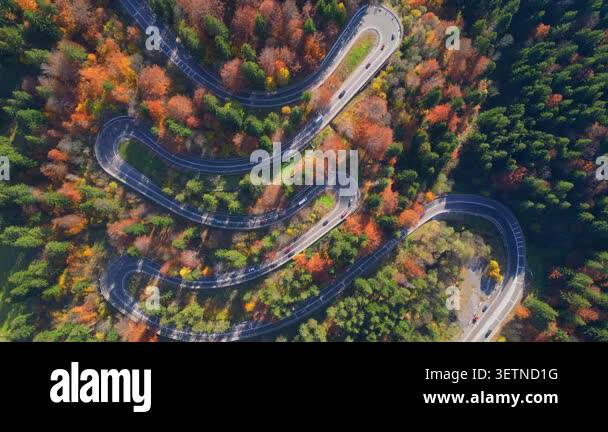 High-angle aerial drone view of a winding serpentine mountain road ...