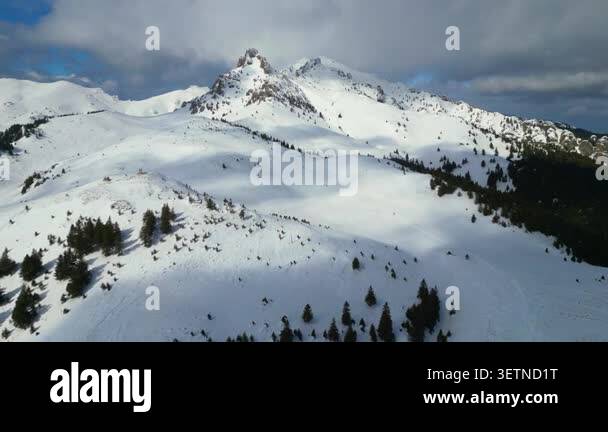 Scenic aerial drone shot of the Ciucas mountain hut surrounded by snow ...