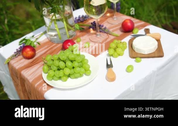 Table setting with cheese, grapes, and fruit outdoors Stock Video ...