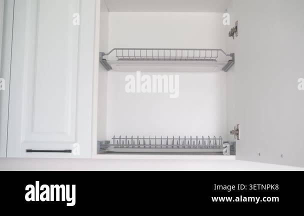Open kitchen cabinet with metal dish rack Stock Video Footage - Alamy