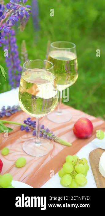 Two glasses of white wine with grapes and fruit on a table Stock Video ...