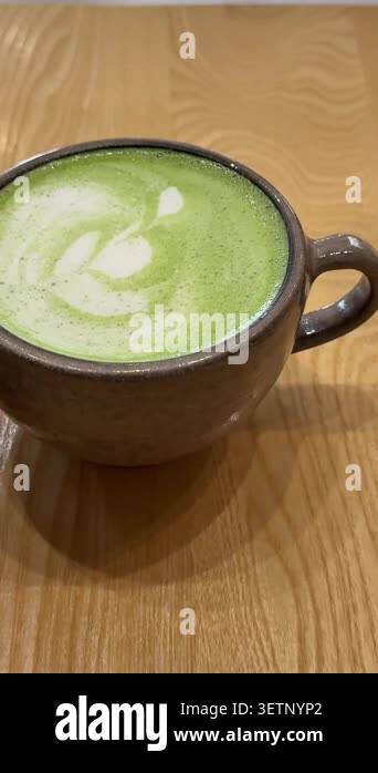 Fresh matcha tea and milk coffee served side by side in gray mugs ...