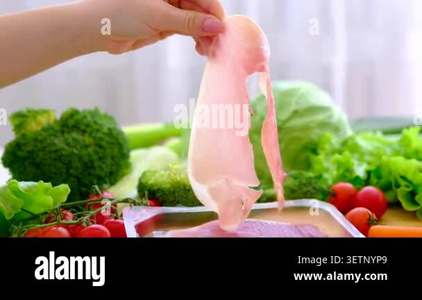 Female hand pulling delicate jamon pieces from transparent packaging ...