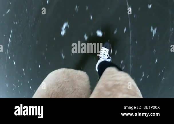 Legs of young sportswoman skating on frozen lake at winter day. Female ...