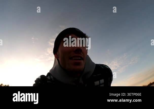 Happy male skater sliding on ice rink during beautiful sunset. Young ...