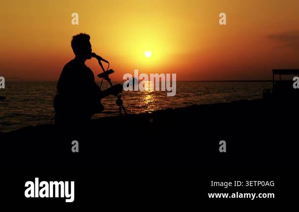 Musician Silhouette Playing Guitar near the Sea in Sunset Light Stock ...