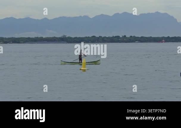 Man paddle boat on ocean water with mountain range. A peaceful, serene ...