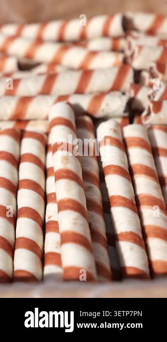 People prepare and shape striped rolls using dough and sweet filling ...