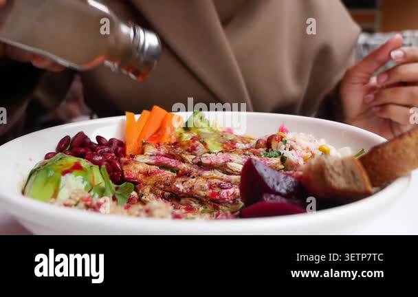 A person adds seasoning to a bowl of rice and salad Stock Video Footage ...