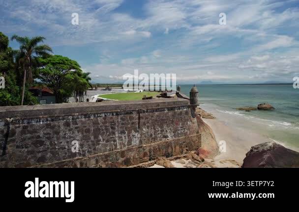 Aerial view of a historic fortress wall along a sandy beach and ocean ...