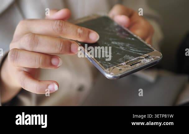 A person touches a smartphone screen with cracks while sitting Stock ...
