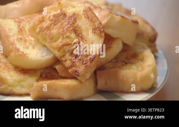 People make French toast using bread, eggs, and milk in the kitchen ...