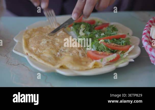 Person prepares an omelette with fresh salad on a plate in a cafe Stock ...