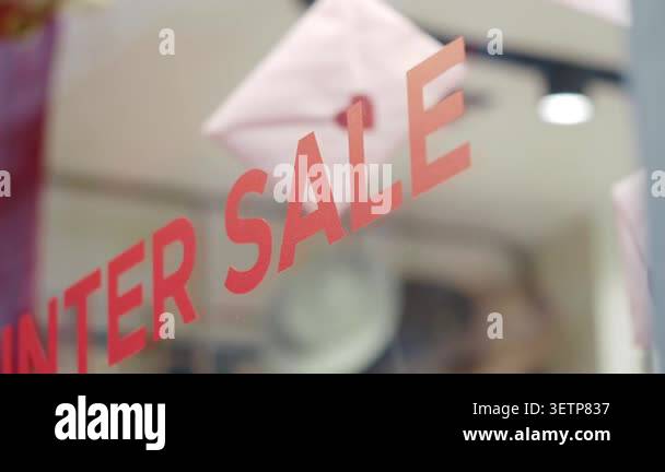 People are looking at winter sale signs in a city shop window Stock ...