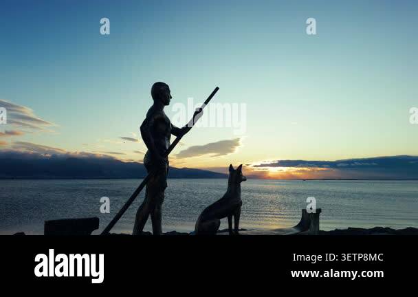 Bronze statue depicting a man and his dog on a raft sailing toward the ...