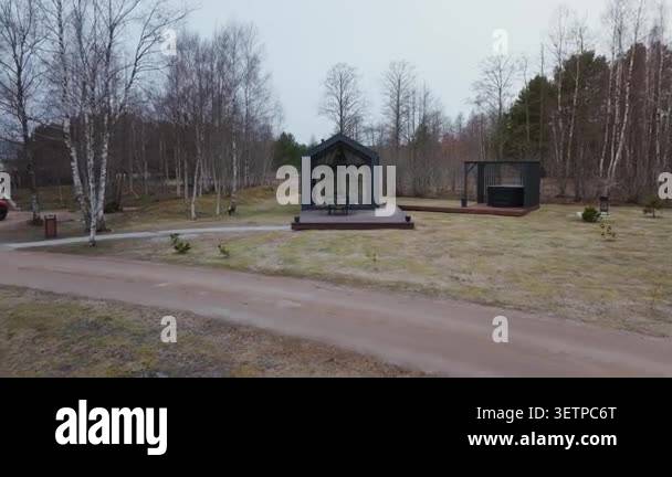Aerial shot frames modern tiny cabin with black cladding and large ...