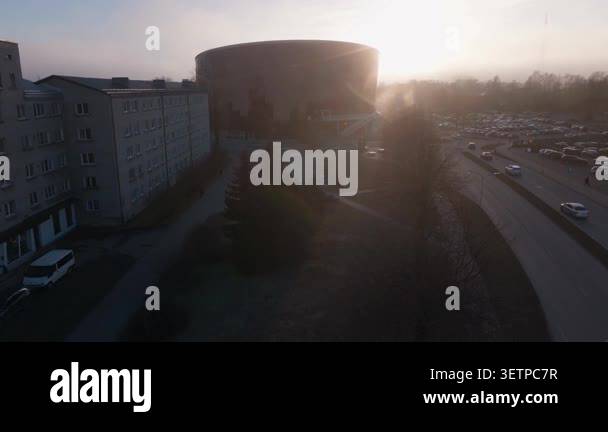 Aerial pan shows a copper hued performance hall with stair tower, a ...
