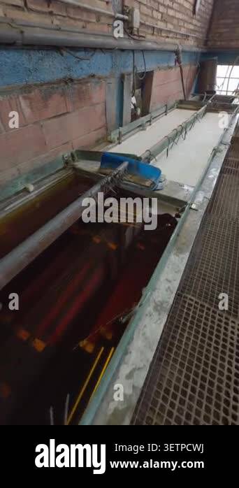 Industrial machinery moving metal parts through chemical baths for ...