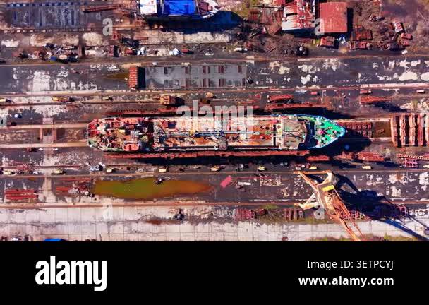 Tanker ship positioned on parallel slipway tracks. Direct topdown drone ...