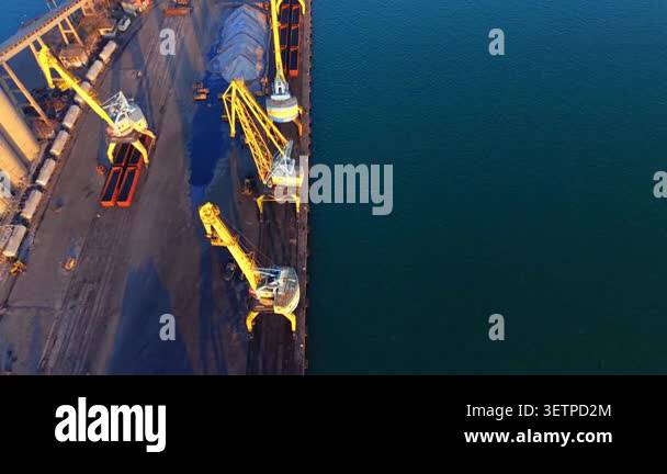 Yellow cargo cranes at a sea dock. Aerial view of heavy industrial ...