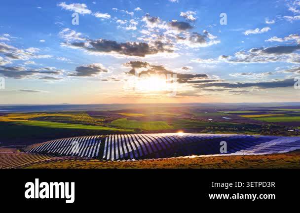 Evening sun rays over a rural solar power station. Wide landscape ...