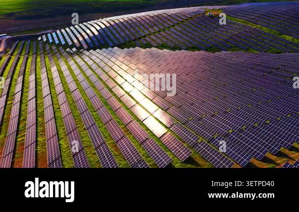 Sunlight reflecting on hillside solar panel rows, shown from a diagonal ...