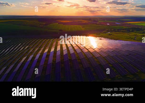 Large solar array reflecting bright sunset glare. High perspective ...
