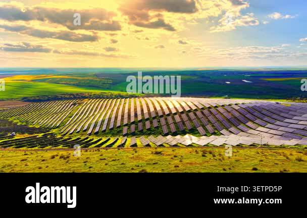 Solar panel system on rolling green pasture. Wide drone view with ...