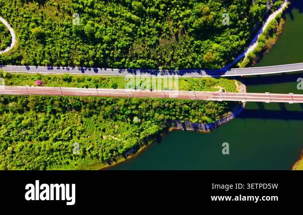 Parallel infrastructure over river. Overhead drone shot captures road ...