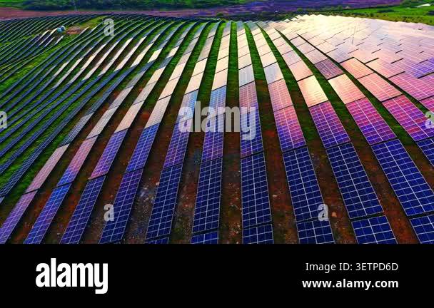 Vast array of colorful photovoltaic modules on a slope, viewed from a ...