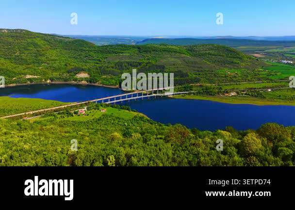 Concrete bridge crossing a calm blue river reservoir, Bulgaria. Wide ...
